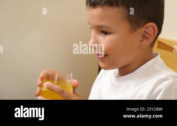 A boy drinks soda from a glass while sitting at the table Stock Video ...