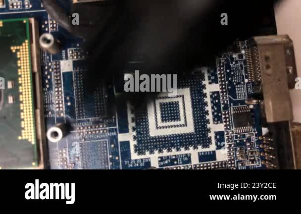 Professional technician cleans laptop motherboard with brush. Computer ...