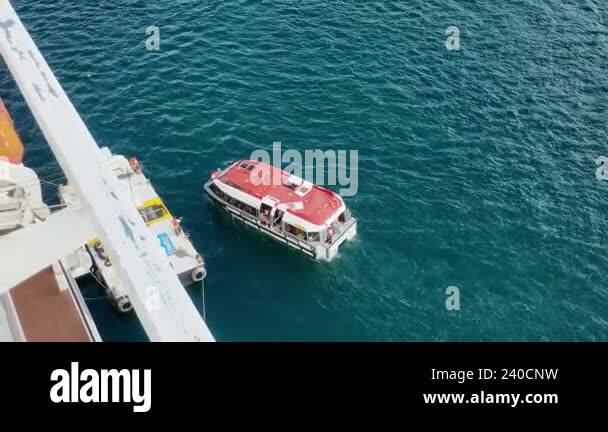 This video shows a small boat skillfully docking with a large cruise ...