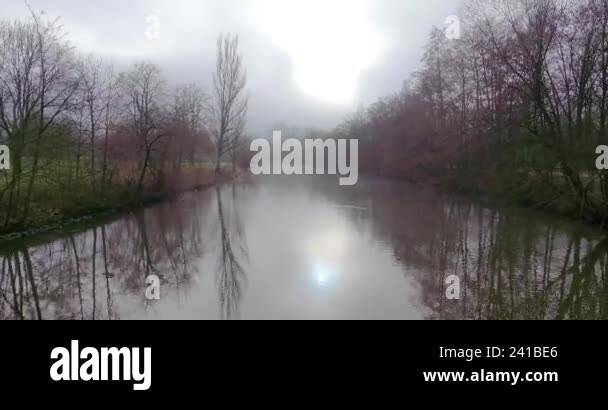 Drone flight over the Nidda River in Frankfurt on a foggy day with ...