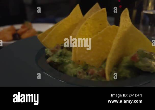 Mexican guacamole and tortilla chips, nachos, top view of slowly ...