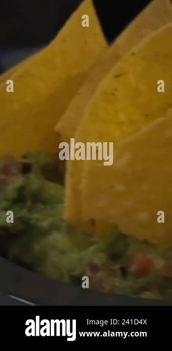Mexican guacamole and tortilla chips, nachos, top view of slowly ...