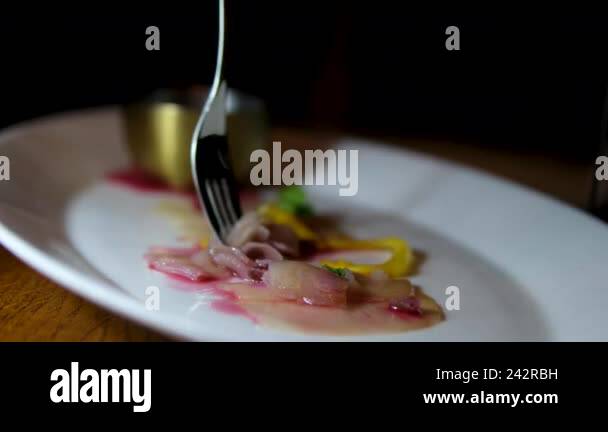 Woman mixing Sliced and chopped tuna fillet and spices in glass bowl ...
