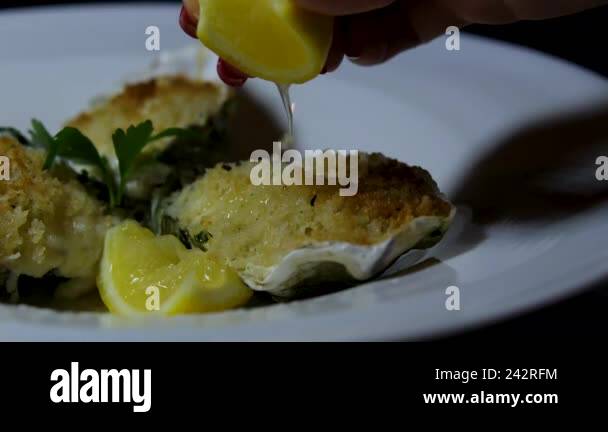 eating oysters in restaurant, closeup view of plate and hands of man ...