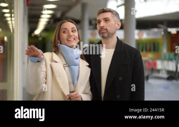 A happy couple celebrates their shopping success, both smiling brightly ...