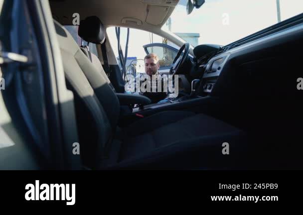 A dedicated car wash worker thoroughly vacuums the cars interior ...