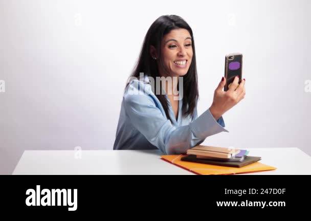 Businesswoman having a funny video call on a smartphone in slow motion ...