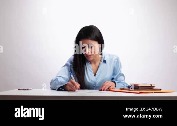 Professional latin businesswoman writing document with concentration ...