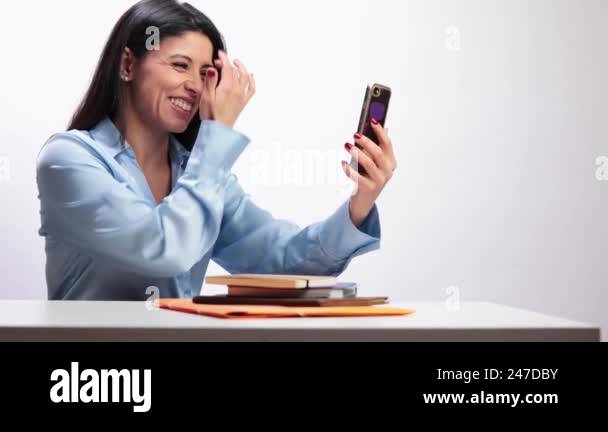 Latin businesswoman having a video call using her smartphone, isolated ...