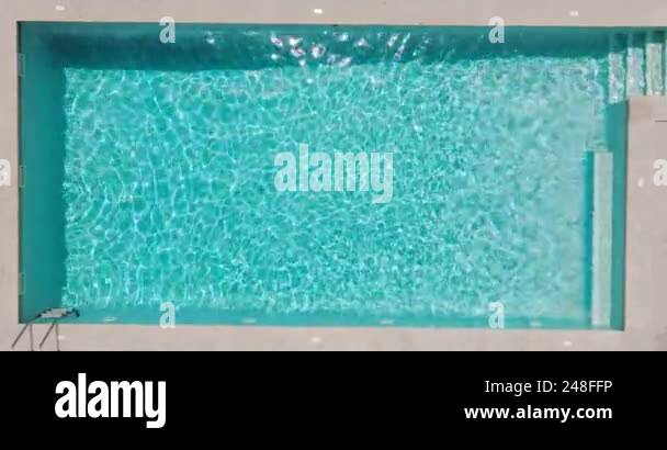 Surface of pure blue water in the swimming pool with light reflections ...