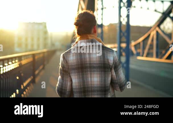 Caucasian businesswoman in a coat, walking around the city in the early ...