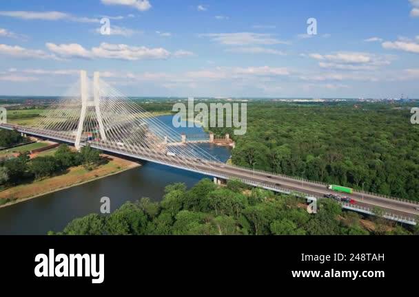 Aerial view of cars and trucks driving on modern cable stayed bridge ...