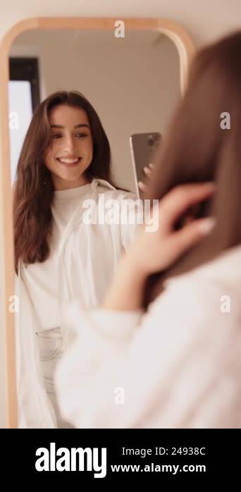 A young, stylish woman captures a happy moment, making a selfie while ...