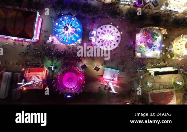Carnival rides and attractions lit up at night. An aerial view of a ...