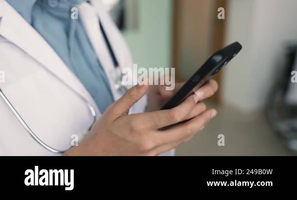 Female doctor typing on mobile phone, texting message, chatting with ...