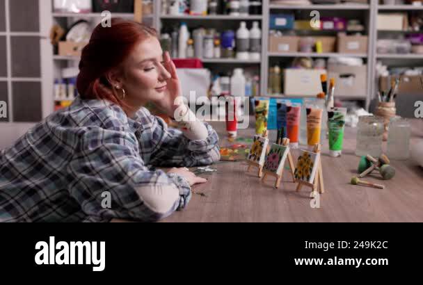 A thoughtful and dedicated artist takes a moment to admire her colorful ...