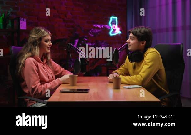 Online podcast. Man host and woman guest recording interview in loft ...