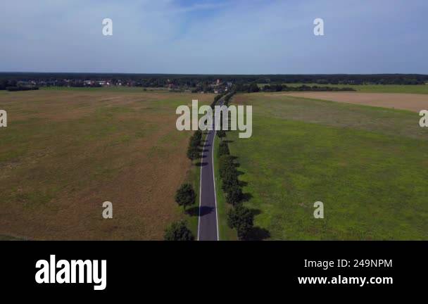 Aerial view of an empty asphalt road crossing a countryside landscape ...
