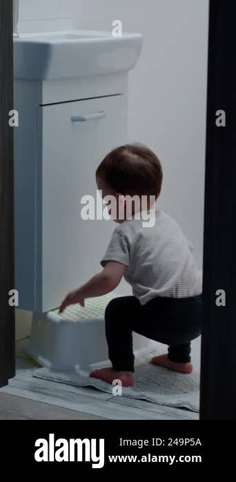 Cute baby boy takes a stand out of the chest. Smart kid stands on the ...