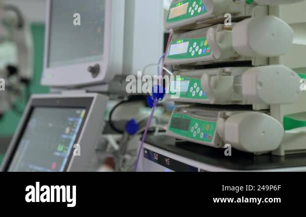 Infusion syringe pumps in the surgery room. Male hand presses on the ...