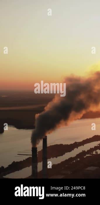 Dirty smoke from industrial chimneys at sunset. Dark chemical fumes ...