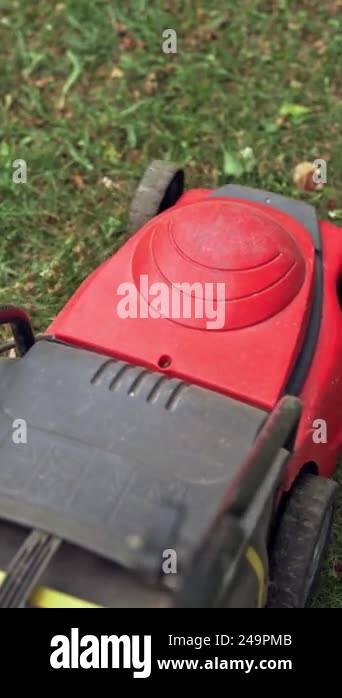 Lawn mower cutting the grass outdoors. Top view of electric lawn mower ...