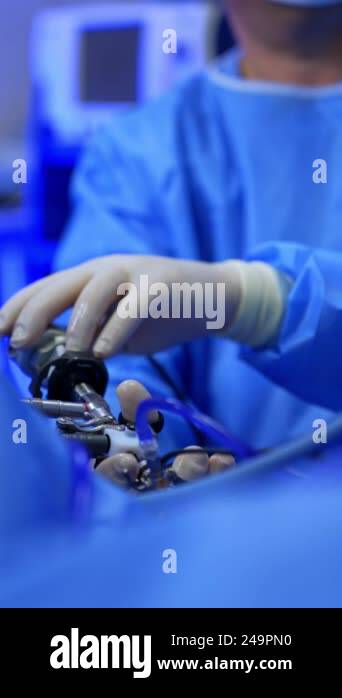 Hands in latex gloves hold and rotate endoscopic instrument ...