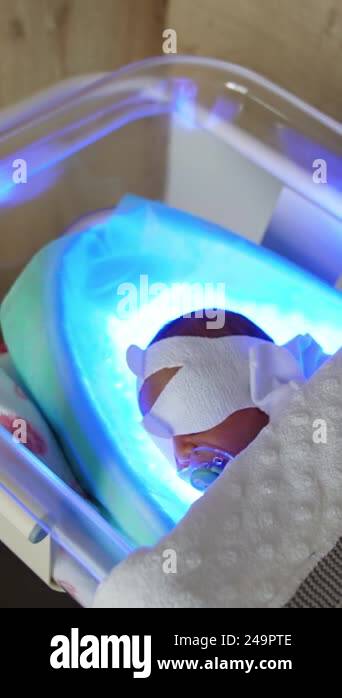 Little baby with mask on eyes and with pacifier in mouth lies in the ...