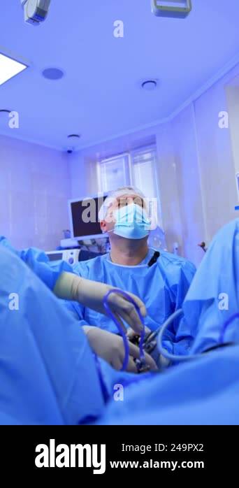 Doctor applies endoscopic tool at operation. Scrub nurse holds the tube ...