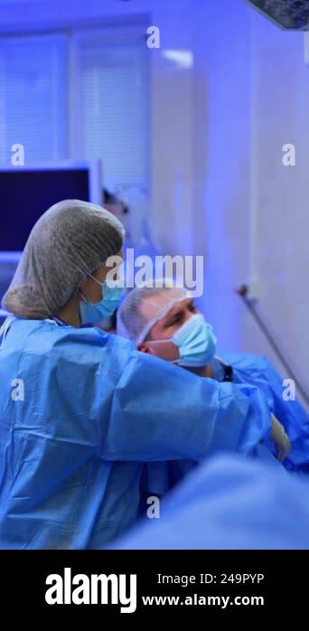 Surgeon assisted by a female scrub nurse perform operation. Medics ...