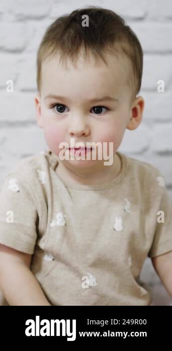 Sweet Caucasian toddler looking at phone shown by parent. Lovely baby ...