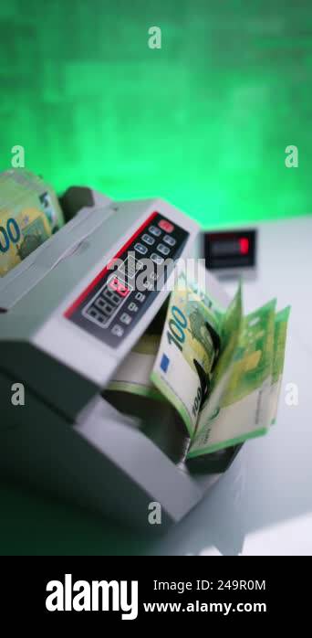 Female hand holding a stack of banknotes in cash counting machine ...