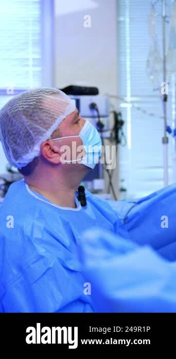 Doctor applies endoscopic tool at operation. Scrub nurse holds the tube ...