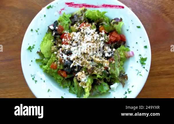 Plate of healthy salad food dish with goat cheese lettuce and olives in ...