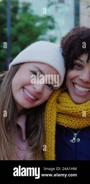 Vertical video. Three diverse women friends happily posing together on ...
