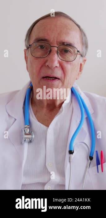 Vertical HD video. POV of senior male doctor talking with patient ...