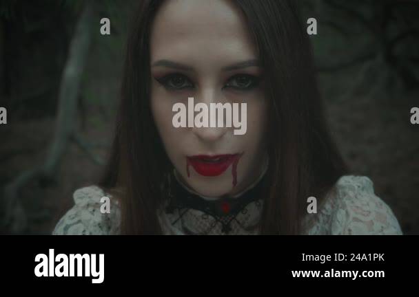 portrait of a young woman vampire, beautiful red lips with dripping ...