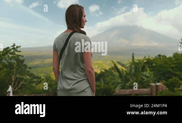 Female tourist is taking in the breathtaking scenery of mayon volcano ...