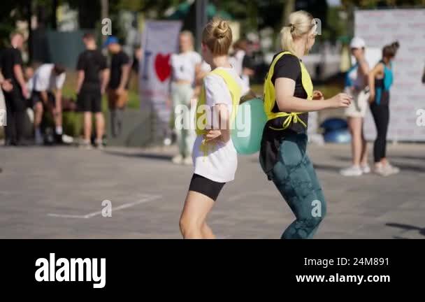 Two women participate in a team building activity outdoors, balancing a ...