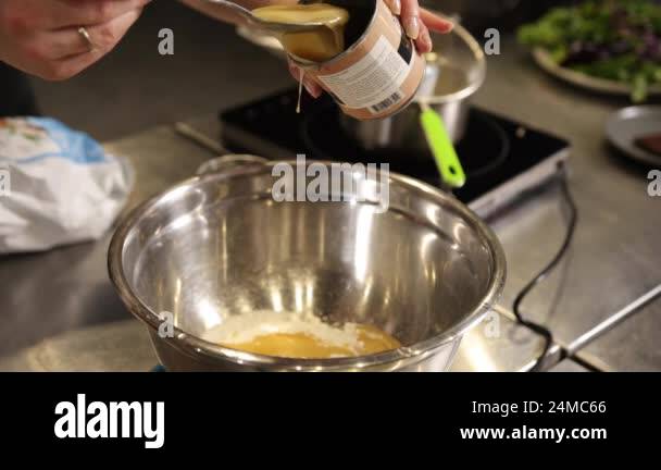 Pouring milk, bowl mixing, milk stream. In close-up shot, condensed ...