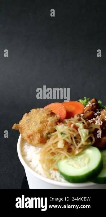 Rotating rice bowl containing teriyaki chicken with rice, vegetables ...