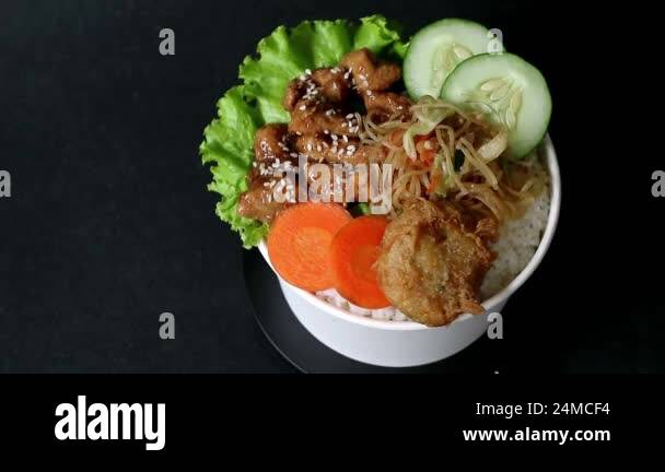 Rotating rice bowl containing teriyaki chicken with rice, vegetables ...