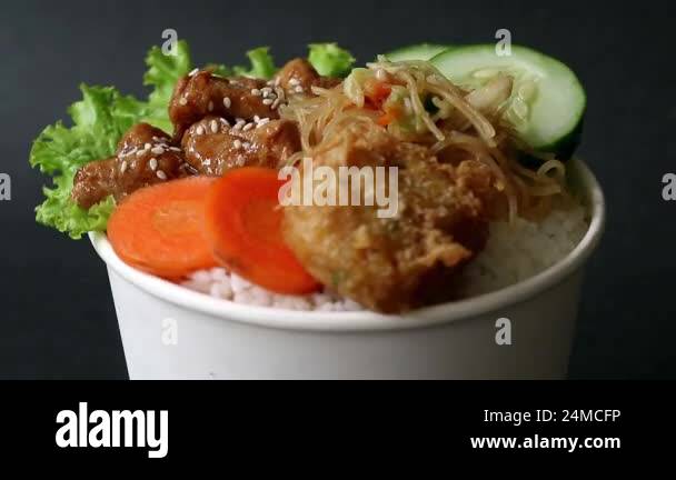 Rotating rice bowl containing teriyaki chicken with rice, vegetables ...