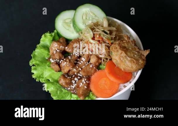 Rotating rice bowl containing teriyaki chicken with rice, vegetables ...