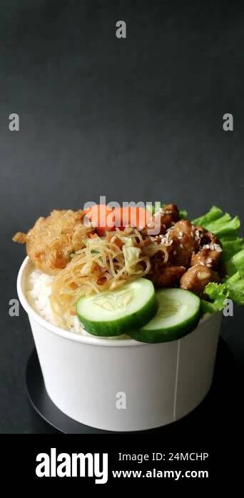 Rotating rice bowl containing teriyaki chicken with rice, vegetables ...