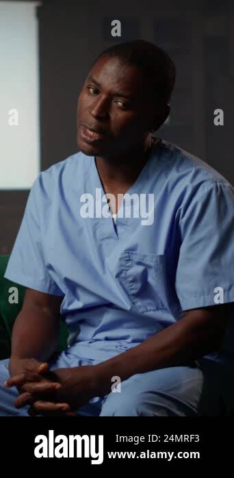 Vertical Video African american medical assistant in scrubs reflects on loss and burnout ...