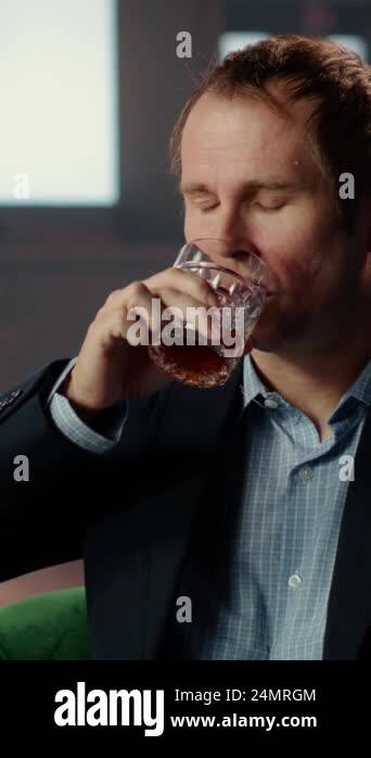 Vertical Video Old money classy heir drinking a glass of whiskey at ...