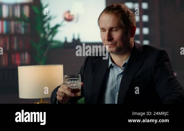 Classy high society member enjoying a glass of whiskey bourbon in a ...