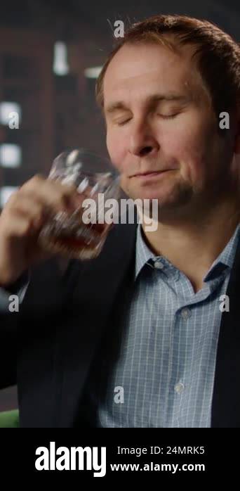 Vertical Video Classy high society member enjoying a glass of whiskey ...