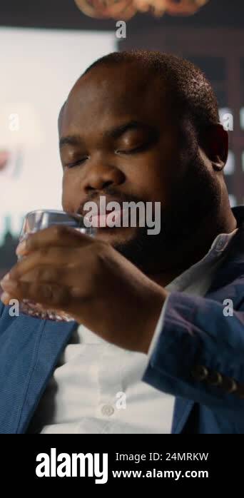 Vertical Video High society billionaire drinking whiskey at the classy ...